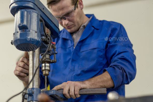 Car mechanic using drill in repair garage Stock Photo by Image-Source