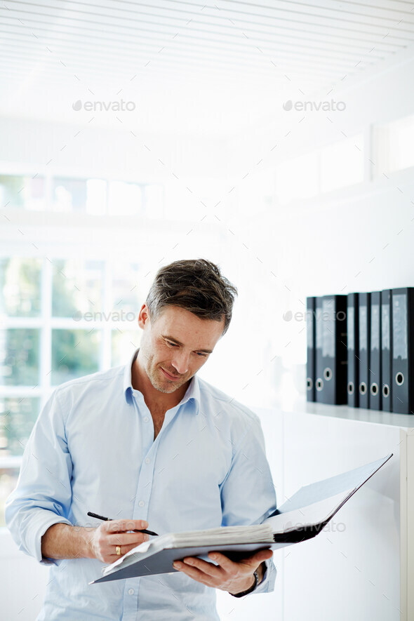 Man looking at folder of paperwork Stock Photo by Image-Source | PhotoDune