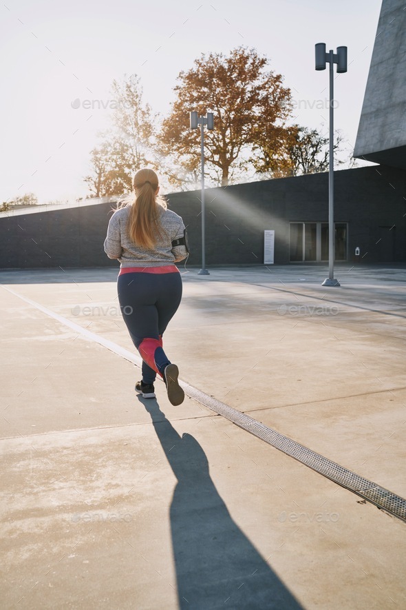 Curvaceous young female runner running, rear view Stock Photo by Image ...