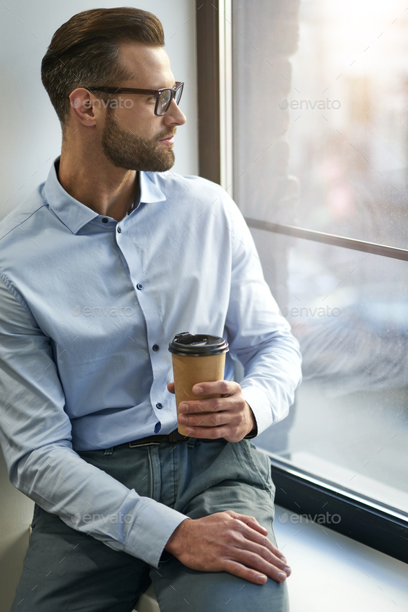 Attractive man sitting and posing on the window sill Stock Photo by ...