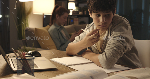 Student doing his homework at home Stock Photo by stokkete | PhotoDune