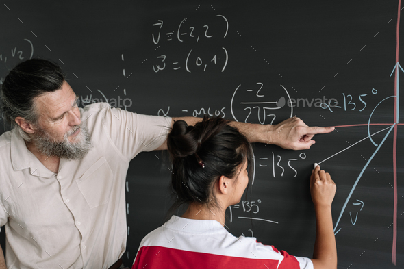 Asian Teenager Student doing Maths Exercises on Blackboard with teacher ...