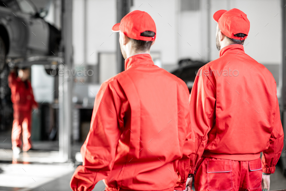 Auto mechanics standing back at the car service Stock Photo by RossHelen