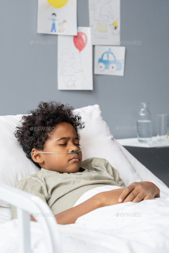 Unconscious sick boy lying at hospital Stock Photo by Pressmaster ...