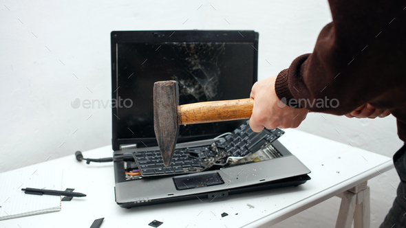 man destroyed laptop with a hammer. Nervous work, buggy computer ...