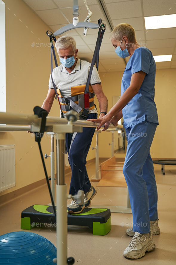 Stroke patient walks between parallel bars at rehabilitation room Stock ...