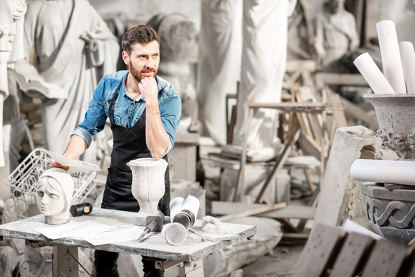 Sculptor working with sculptuers in the studio Stock Photo by RossHelen