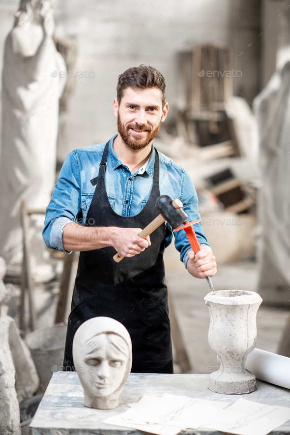 Sculptor working with sculptuers in the studio Stock Photo by RossHelen