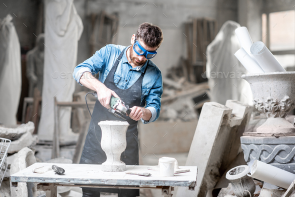 Sculptor working with sculptures in the studio Stock Photo by RossHelen