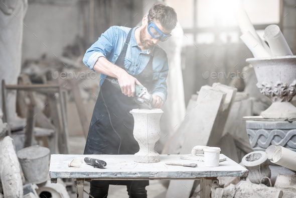 Sculptor working with sculptures in the studio Stock Photo by RossHelen