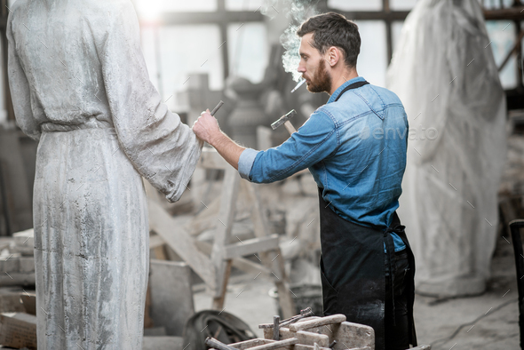 Sculptor working with sculptures in the studio Stock Photo by RossHelen