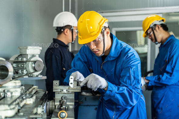 Asian mechanical workers working on milling machine. Stock Photo by s_kawee