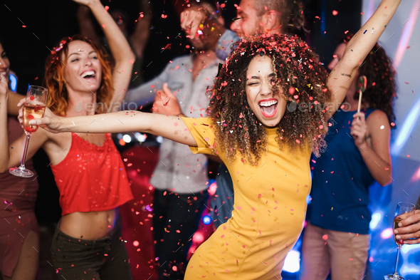 Young multiracial people dancing and celebrating with champagne at ...