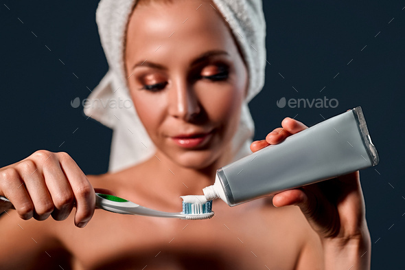 Portrait of attractive young woman on grey background with toothbrush ...
