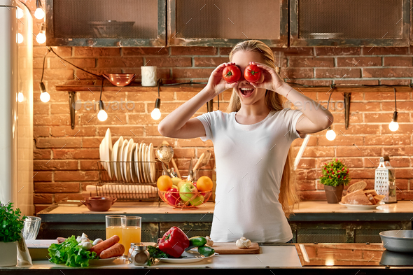 Happiness is cooking Happy young woman cooking vegetables in modern ...