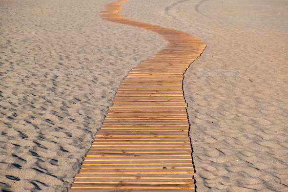 Beach boardwalk. Wooden planks winding empty walkway on sandy beach ...