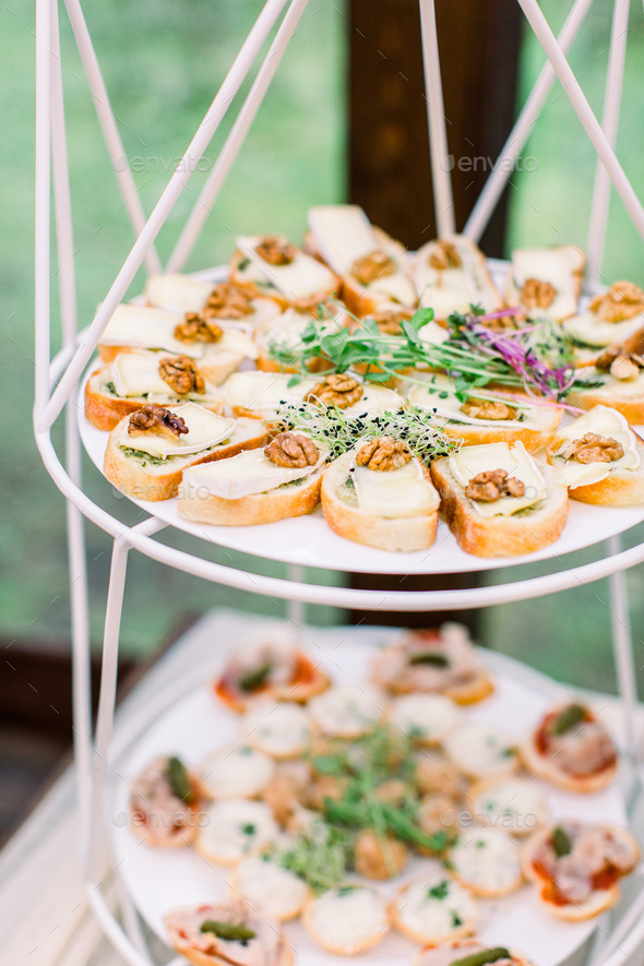 Mini canapes food. Beautiful decorated catering banquet, wooden stands ...