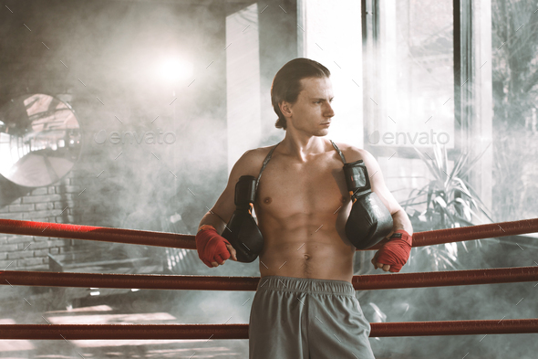 Male boxer having muscular body standing inside a boxing ring. Boxer ...