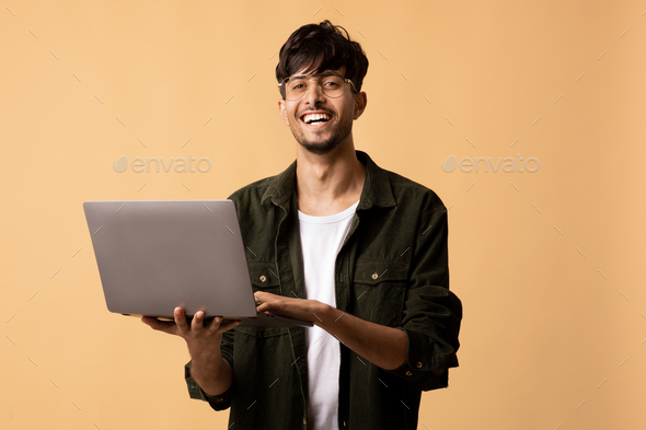 Happy indian guy freelancer using modern laptop, programming Stock ...