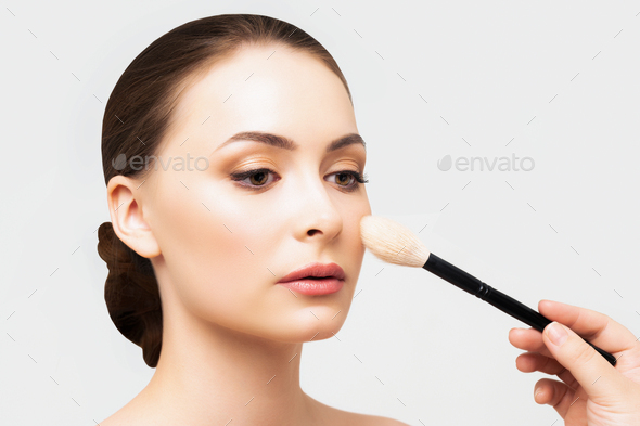 Model doing makeup. Make-up artist and beautiful woman. Girl face ...