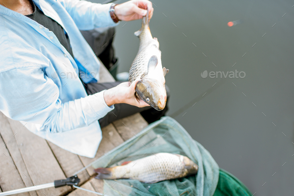 Fisherman holding caught fish Stock Photo by RossHelen | PhotoDune