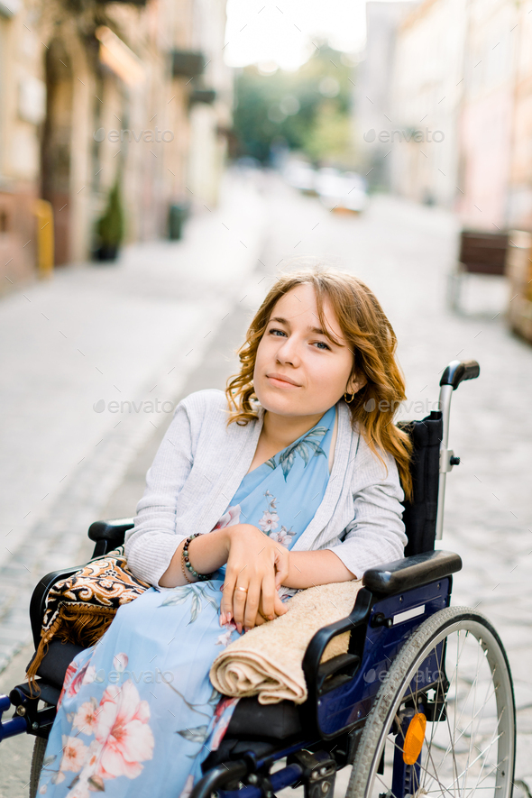 Closeup portrait of pretty young smiling disabled woman in blue dress ...