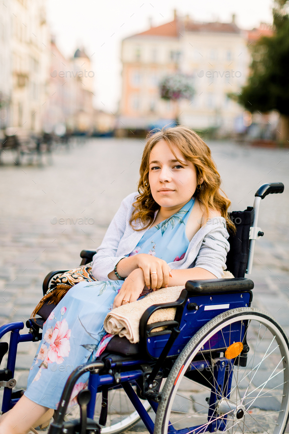 Closeup portrait of pretty young smiling disabled woman in wheelchair ...