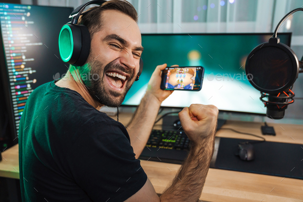 Young man gamer playing video games on smartphone Stock Photo by ...