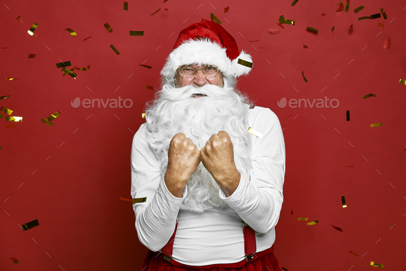 Caucasian Santa Claus cheering with confetti Stock Photo by gpointstudio