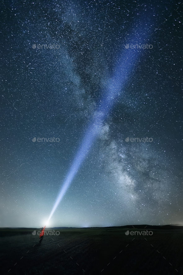 Starry sky and person with ray of light Stock Photo by ADDICTIVE_STOCK