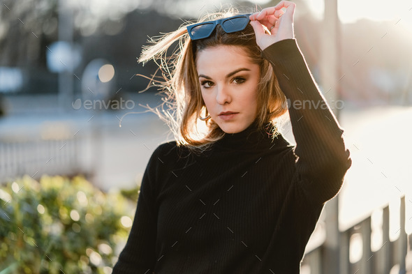 Girl taking off her sunglasses on the street Stock Photo by ADDICTIVE_STOCK