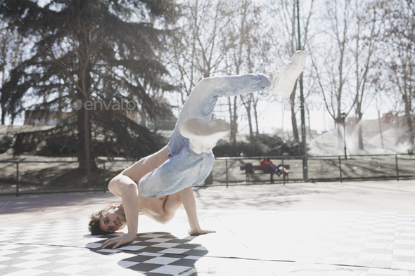 Shirtless man dancing break dance in park Stock Photo by ADDICTIVE_STOCK