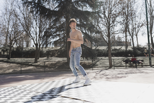 Shirtless man dancing break dance in park Stock Photo by ADDICTIVE_STOCK