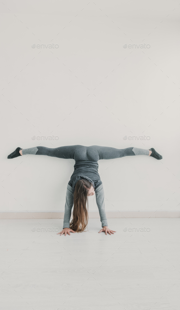 Flexible lady doing handstand with legs to sides in studio Stock Photo ...
