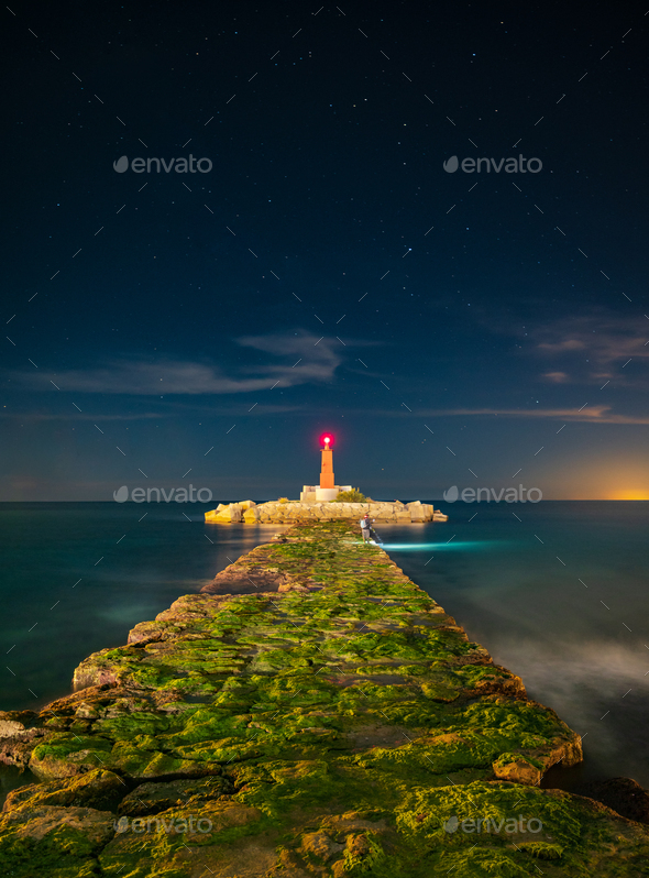 Rough path to bright beacon in evening Stock Photo by ADDICTIVE_STOCK