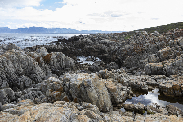 Rocky jagged coastline, eroded sandstone rock, view out to the ocean ...