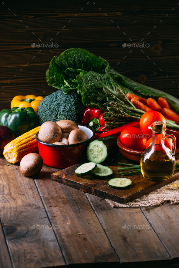 Vegetables and utensils on kitchen table Stock Photo by ADDICTIVE_STOCK