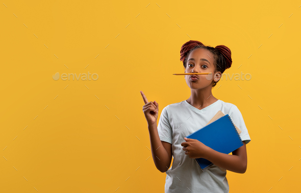 Smart black girl schooler with books showing eureka gesture Stock Photo ...
