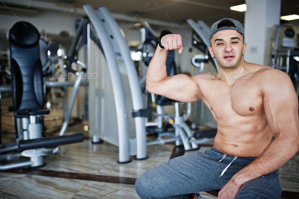 Fit and muscular arabian man doing workouts in gym. Stock Photo by ...