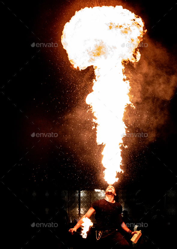 Man blowing fire to the air during nighttime Stock Photo by scopioimages