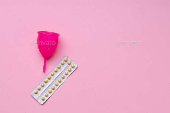Menstrual cup and oral contraceptive pills top view Stock Photo by ...