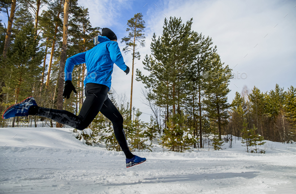 male runner running on snowy trail Stock Photo by realsportsphotos