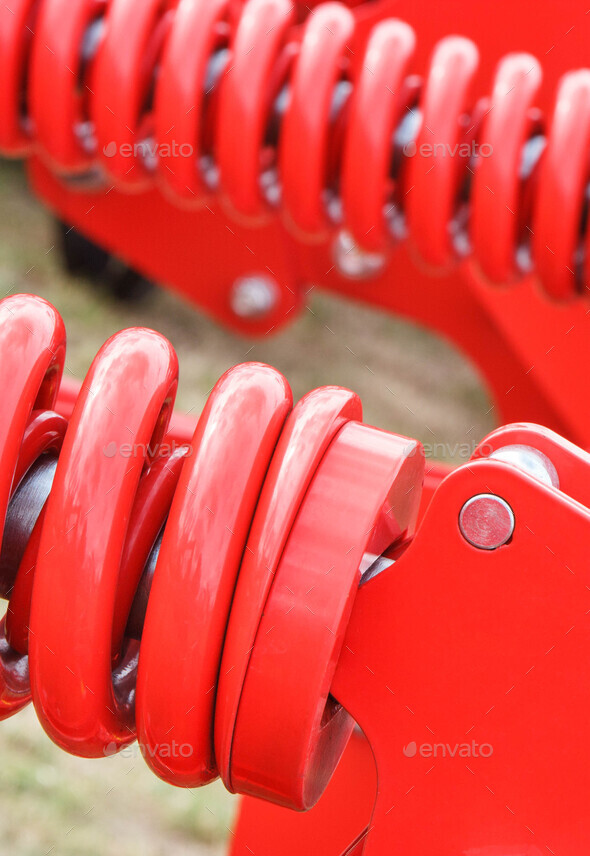 Hard red spring made of steel. Part of big industrial or agricultural ...