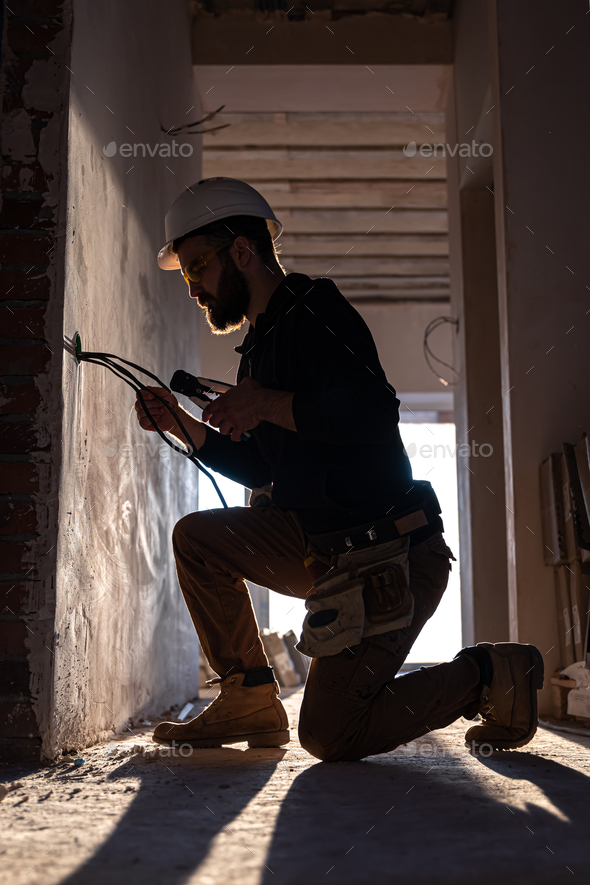 Worker is cutting wires with lineman's pliers. Stock Photo by puhimec