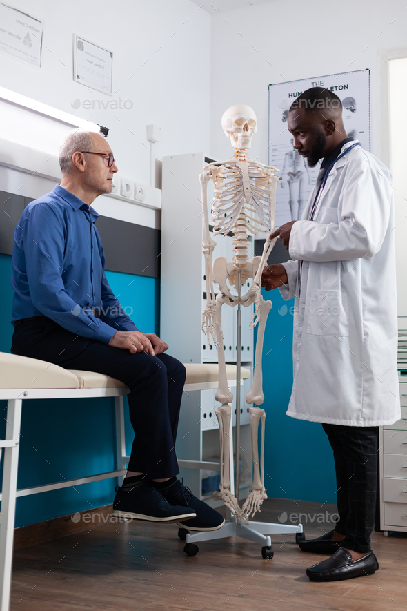 Specialist chiropractor doctor showing human skeleton explaining back ...