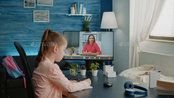 Schoolgirl and teacher using video call for remote lessons Stock Photo ...