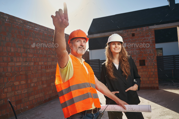 Construction site professionals looking over their area of expertise ...