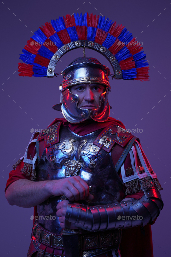 Powerful roman centurion posing against purple studio background Stock ...