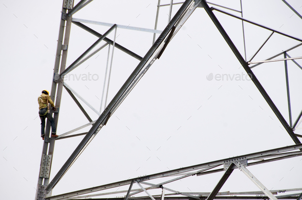 Pylon construction workers working on the top of power tower. Stock ...