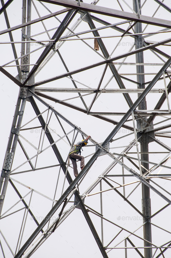 Pylon construction workers working on the top of power tower. Stock ...